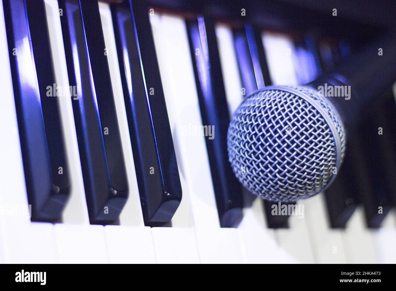 Microphone over piano keys in dim light. No people Stock Photo - Alamy