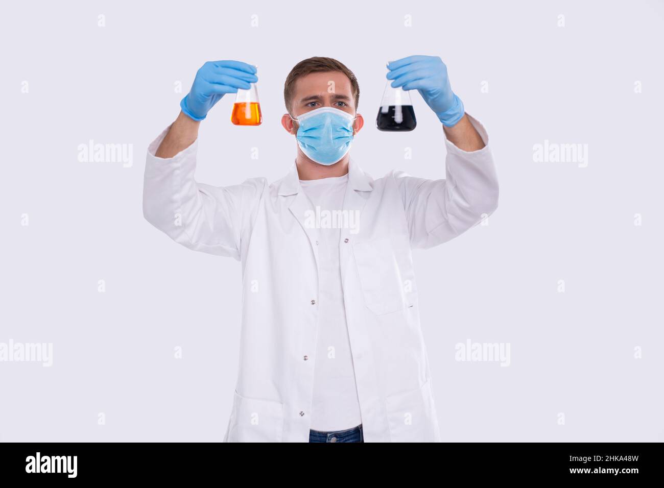 Male Doctor Examing Flask with Colorfull Liquid Wearing Medical Mask ...