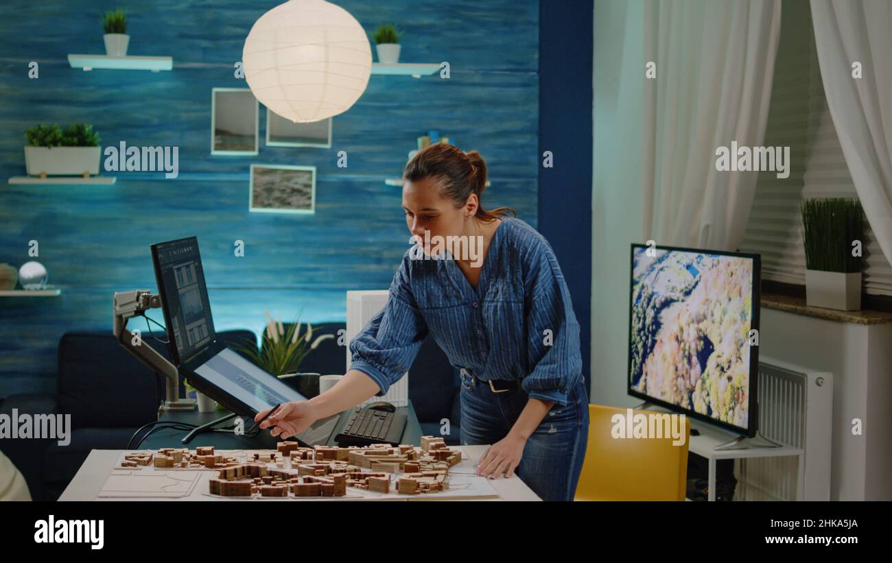 Woman Architect Checking Blueprints And Maquette Analyzing Model For Construction Layout Of