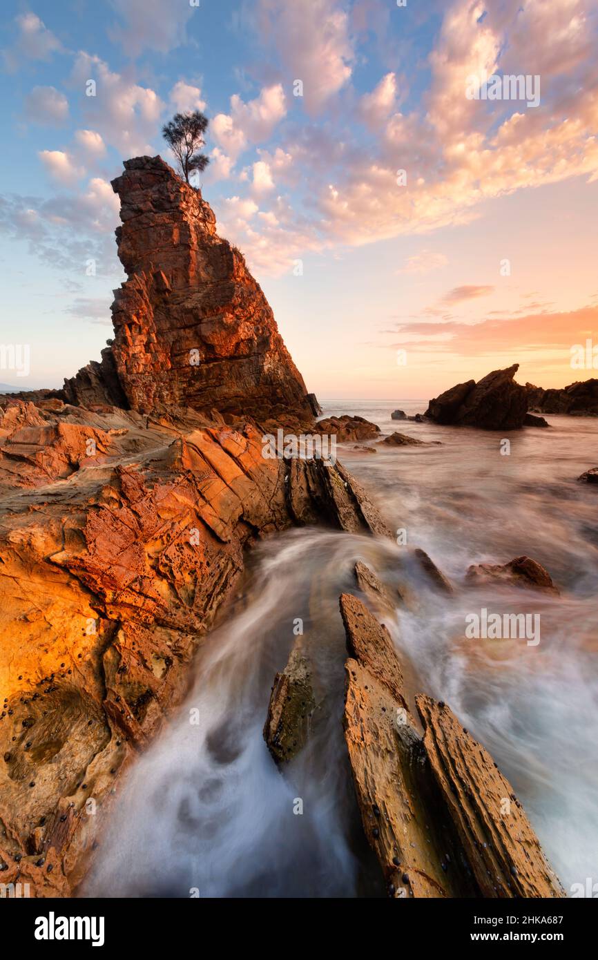 Tall pinnacle rock with cotton candy clouds after sunrise Australia ...