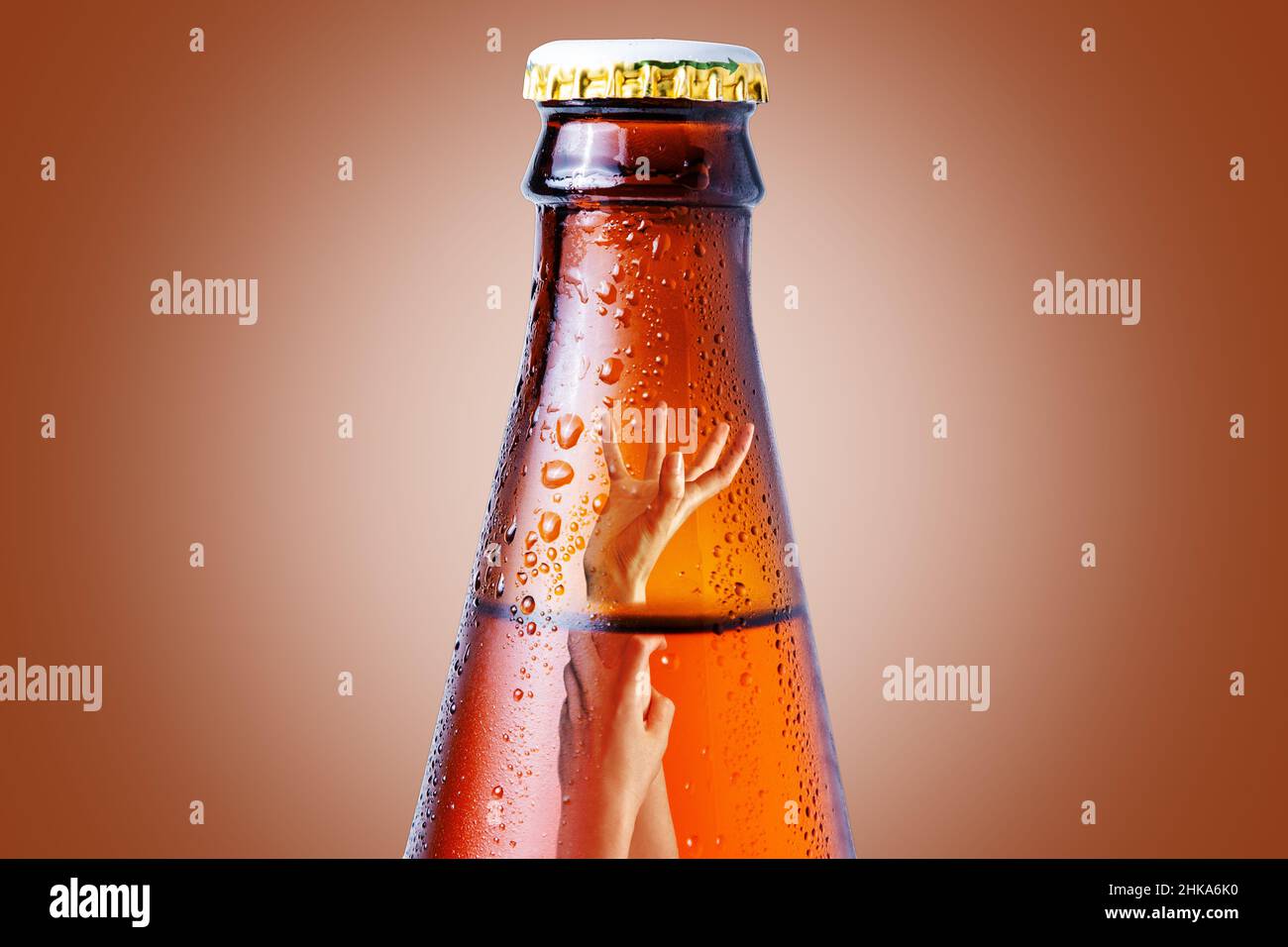 Close-up of the neck of a wet glass bottle of dark beer on a brown ...