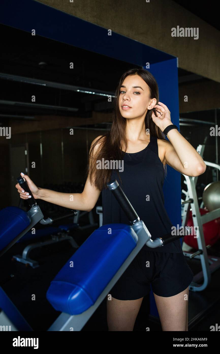Young beautiful woman performs exercise in modern gym club Stock Photo ...