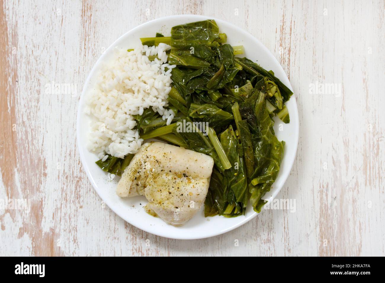 boiled fish with rice and kale on white plate Stock Photo - Alamy