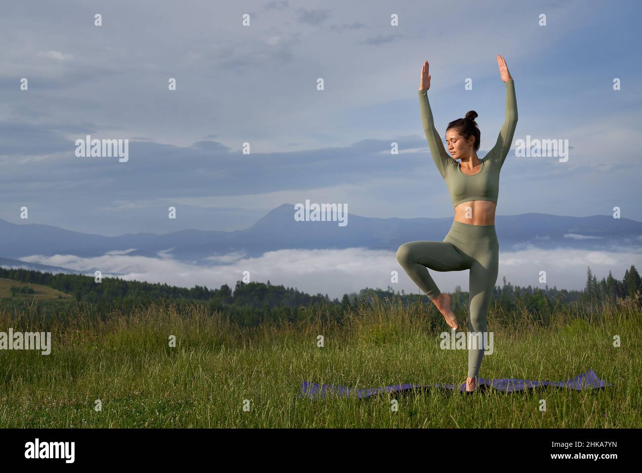 Brunette woman keeping balance and preparing for practice Sun ...