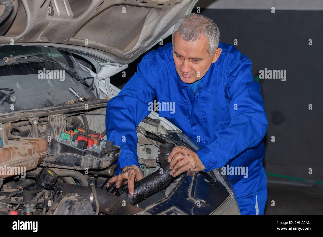 Senior experienced mechanic repairing a car at garage Stock Photo - Alamy