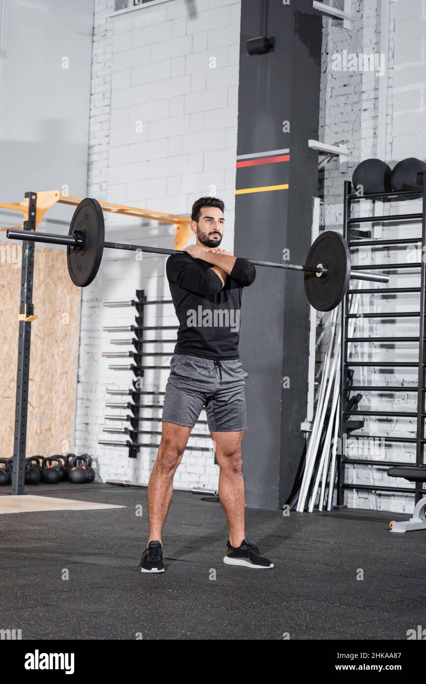 Young muslim sportsman working out with barbell in sports center Stock ...
