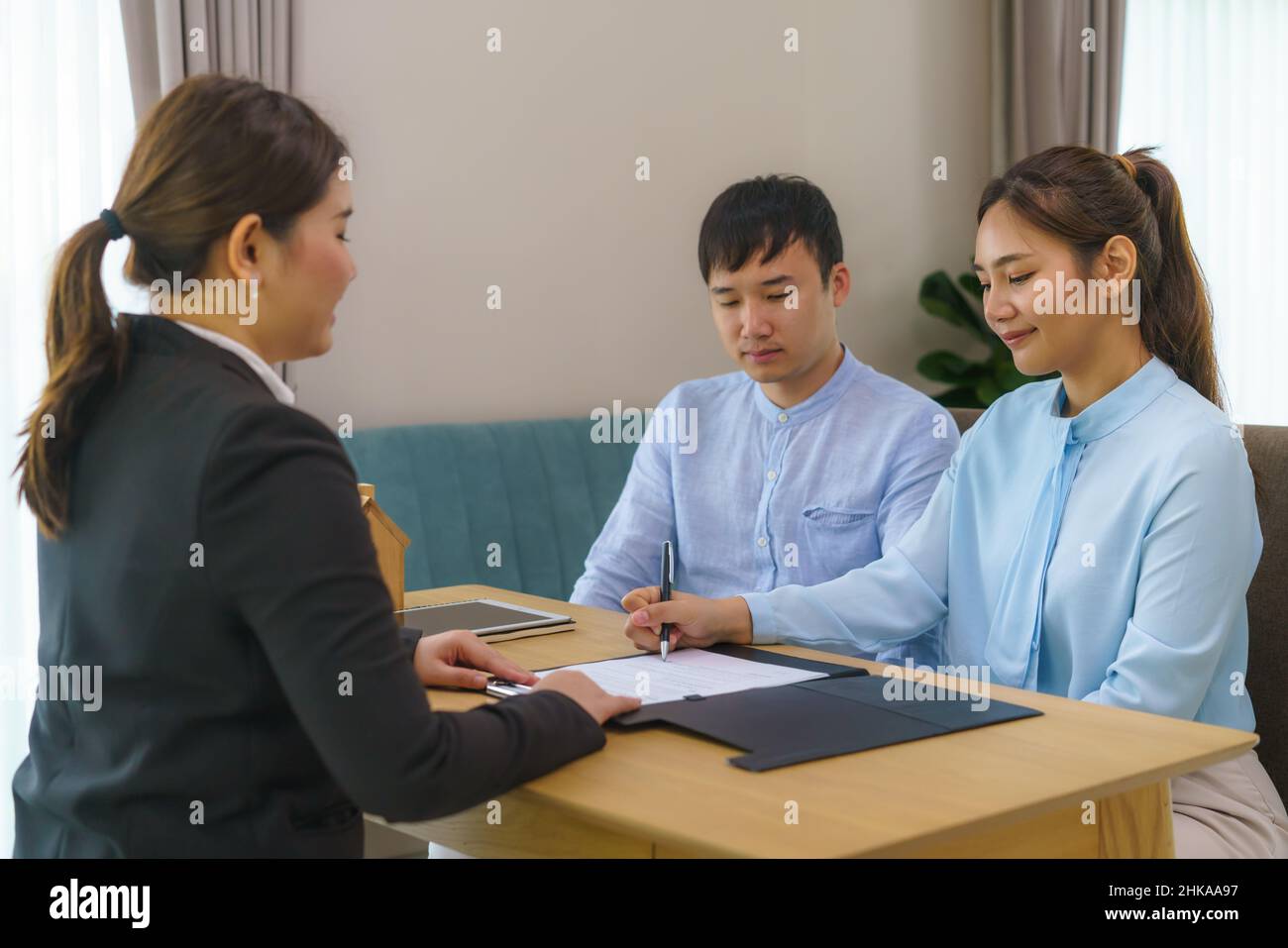 Asian Womans Real Estate Agents Are Having Clients Sign Contracts To Sell Their Homes Stock