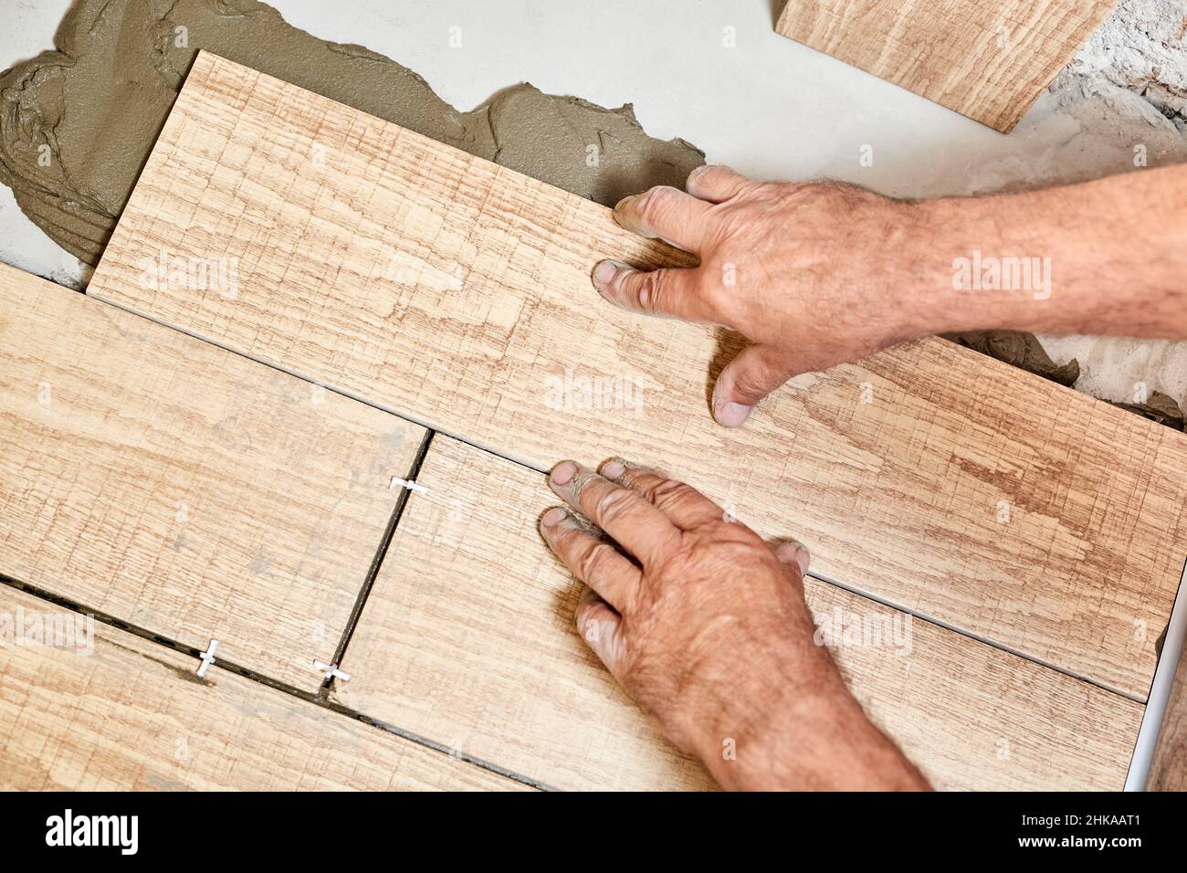 Man laying ceramic floor tiles. Close-up, selective focus Stock Photo ...