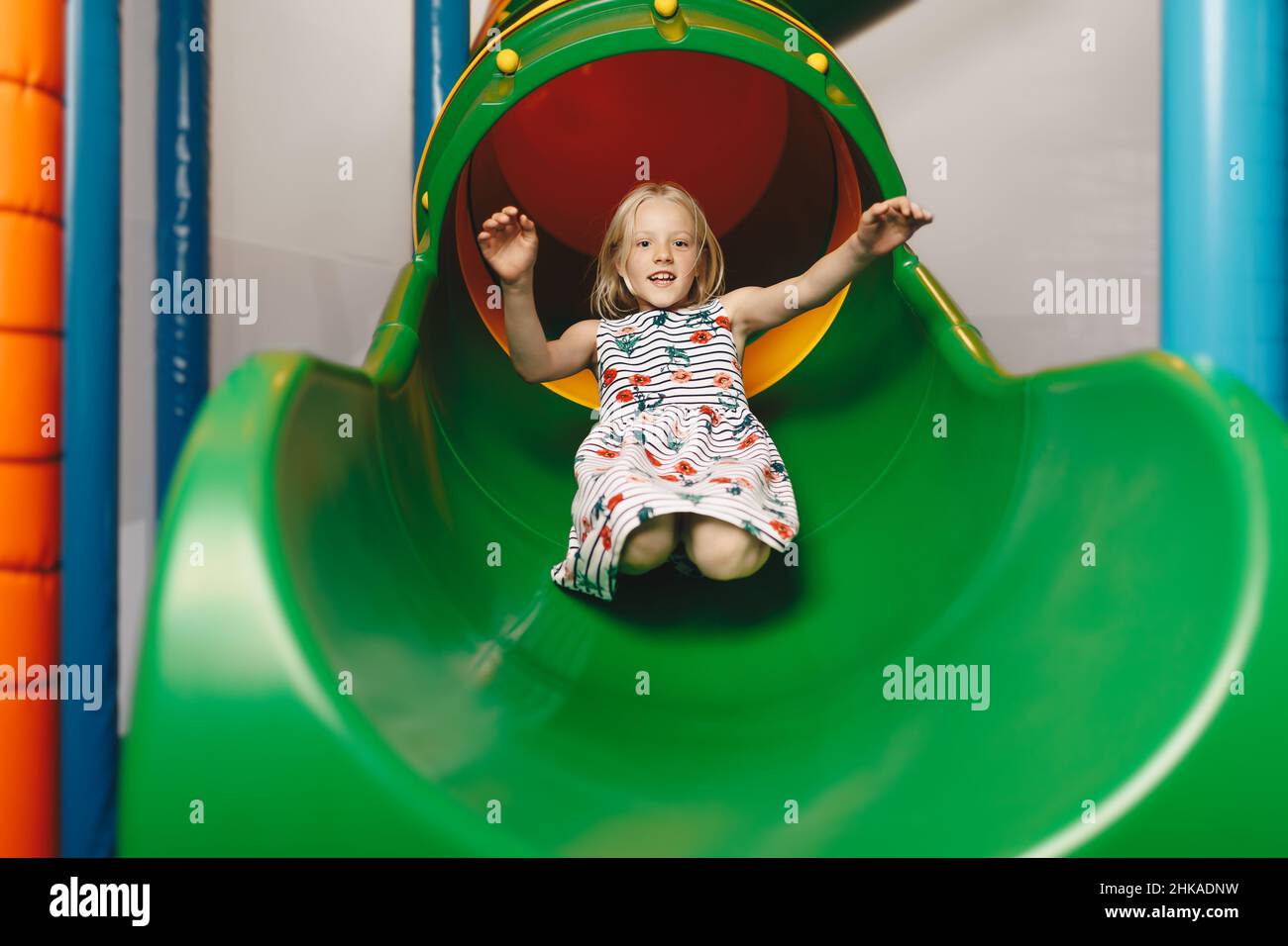 Happy School Girl Sliding In Tube Slide On Playground Park. Joyful Kid ...