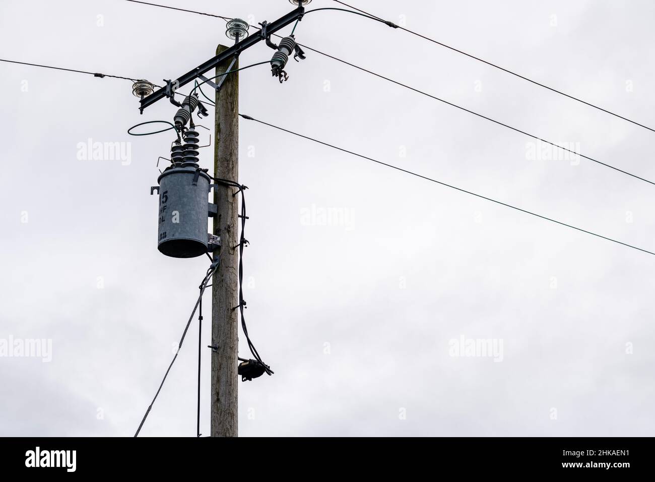 External transformer suspended on a wooden power bracket into electric ...
