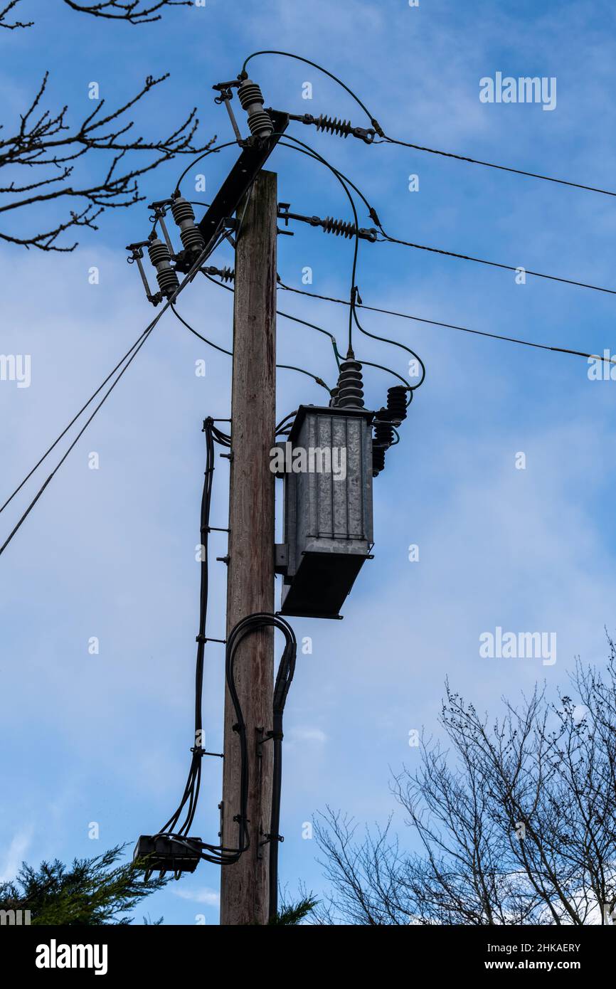 External transformer suspended on a wooden power bracket into electric ...