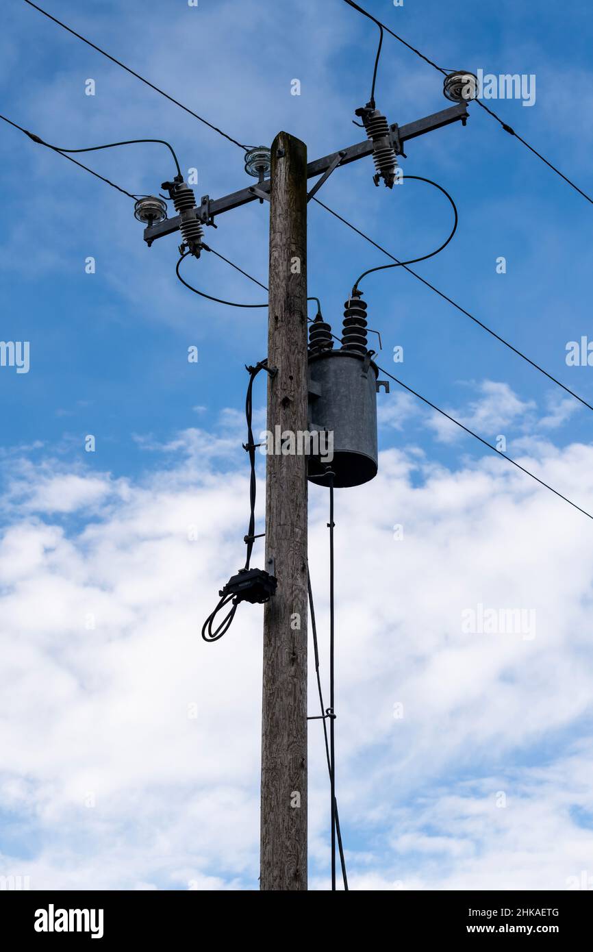External transformer suspended on a wooden power bracket into electric ...