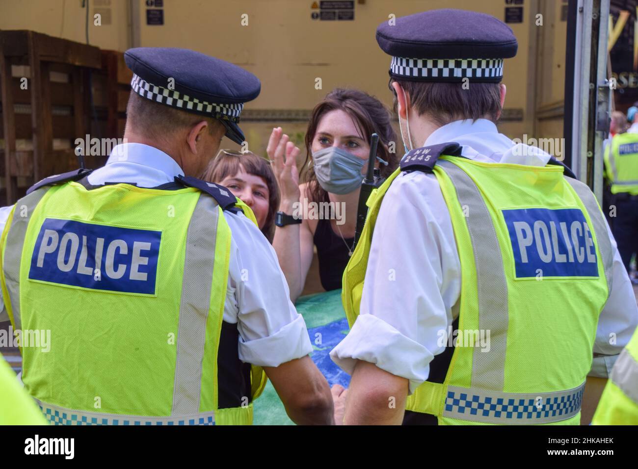 Police officers talk to a demonstrator who attached herself to a van ...