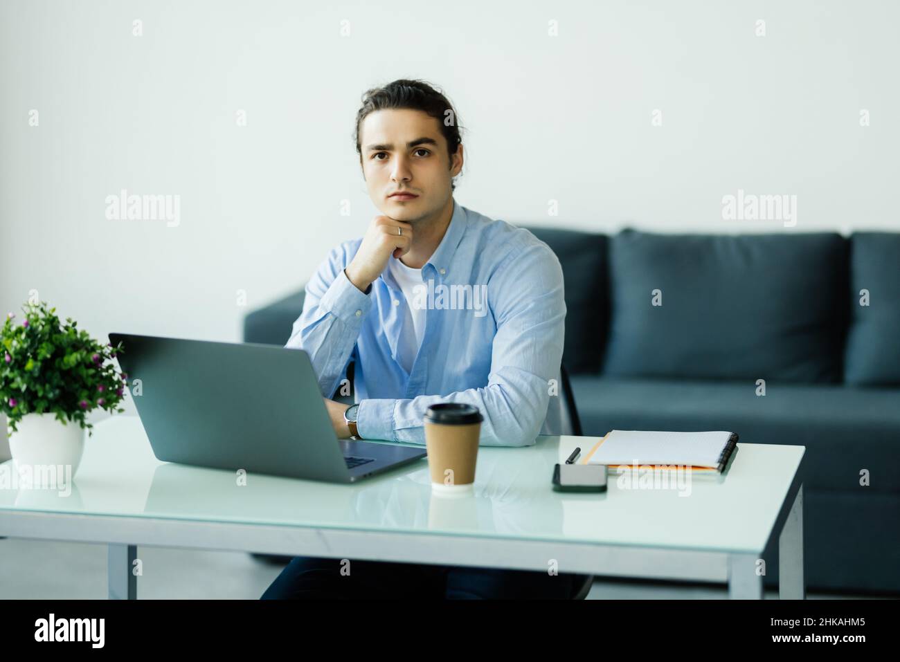 Serious Businessman working at laptop typing something in office Stock ...