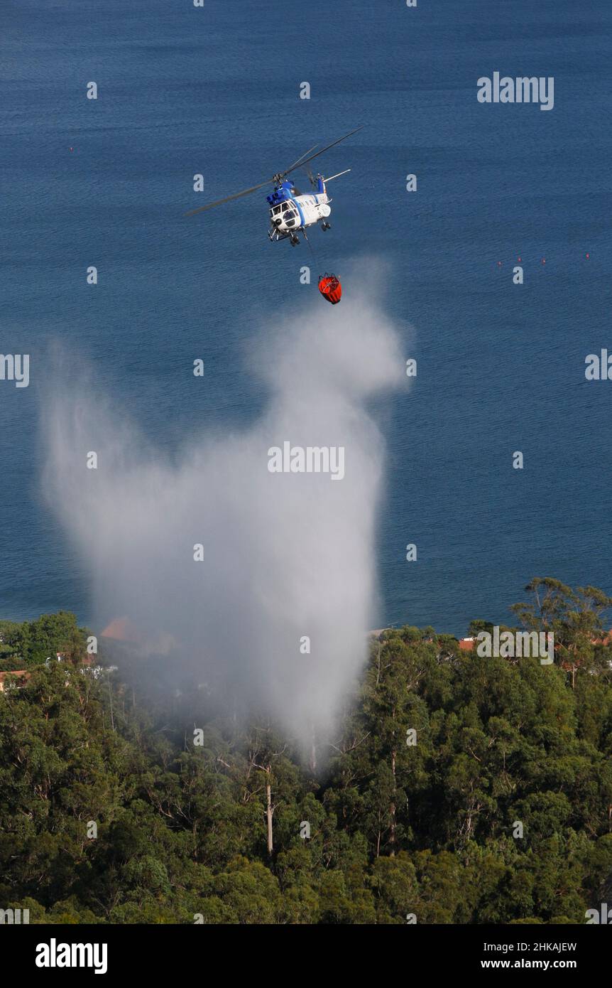 A firefighting helicopter drops water on a forest fire Stock Photo - Alamy