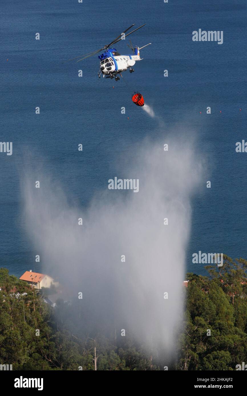 A firefighting helicopter drops water on a forest fire Stock Photo - Alamy