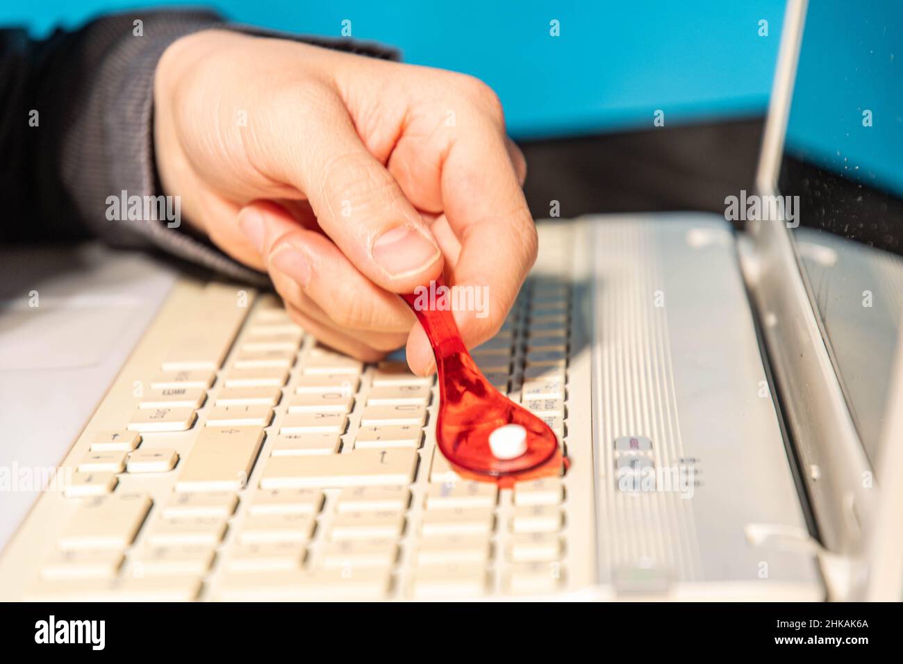 red plastic spoon with medicine on the laptop keyboard Stock Photo - Alamy