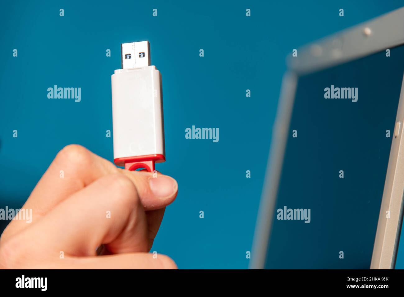 Boy shows white data stick in the air in front of turquoise Stock Photo ...