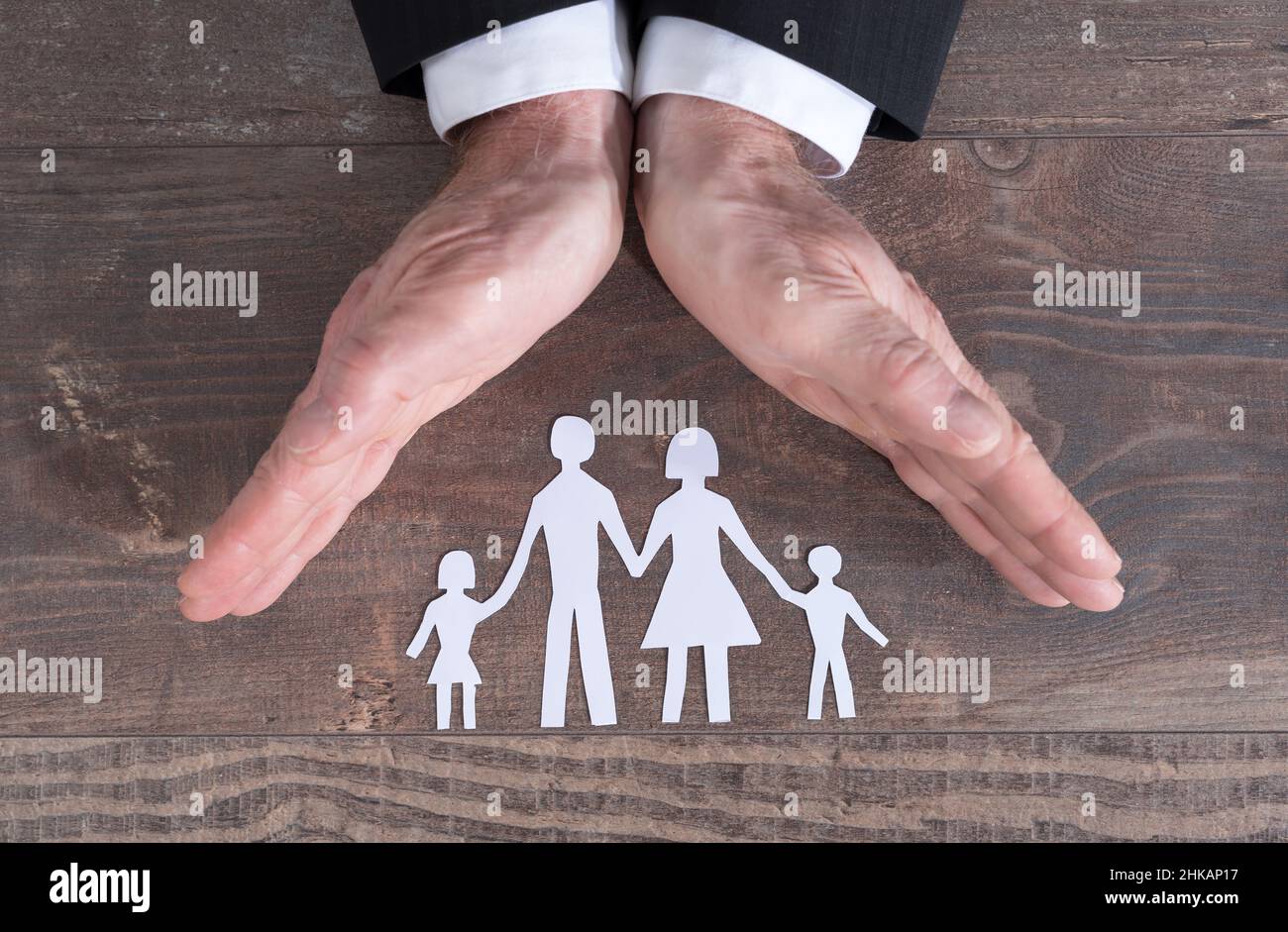 Family covered by hands - insurance concept Stock Photo - Alamy