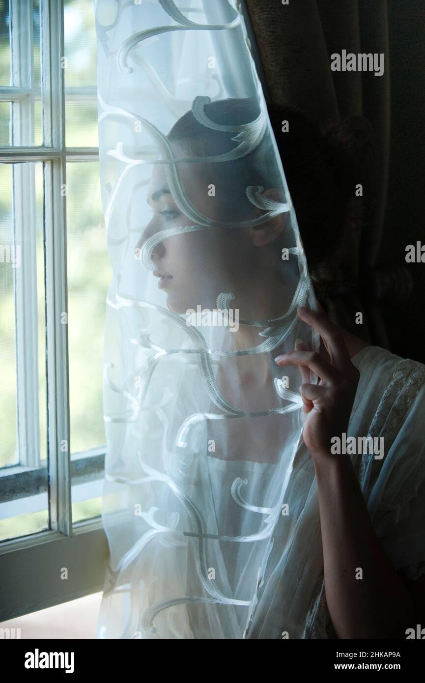 Woman face behind curtains hi-res stock photography and images - Alamy