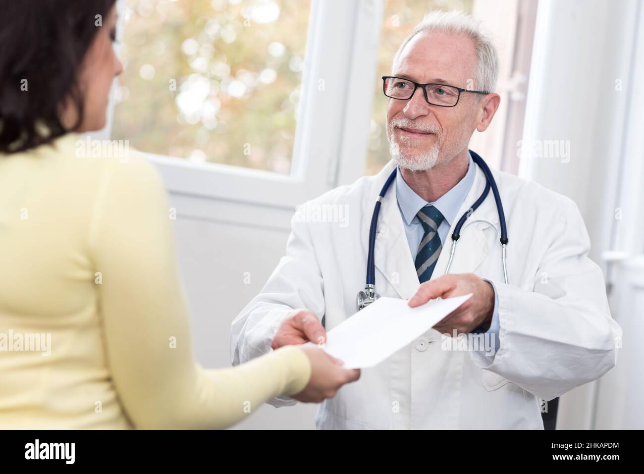 Doctor giving prescription to young patient in medical office Stock ...