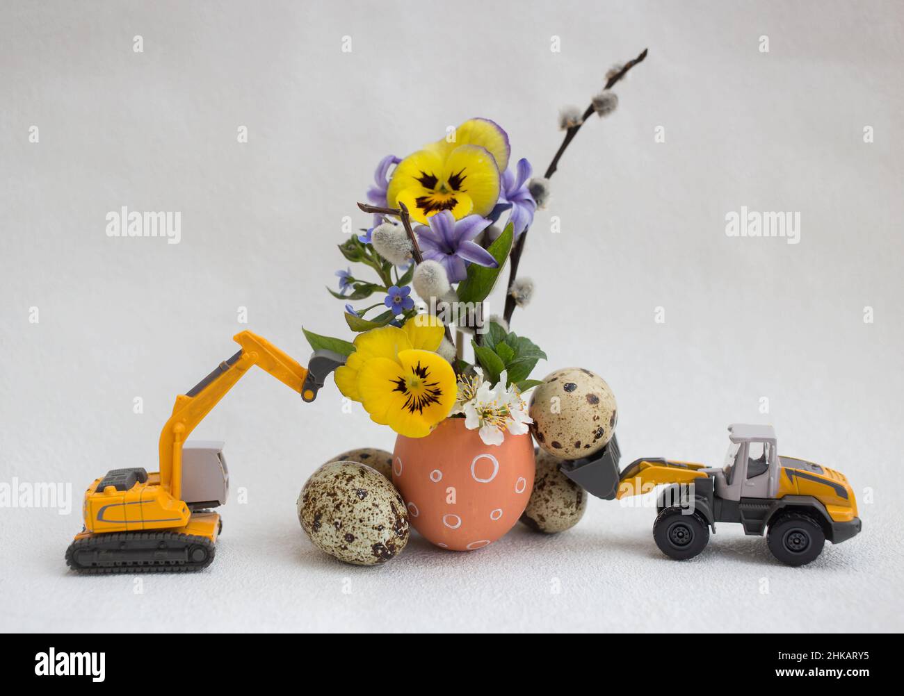 two models of a toy excavator with an Easter composition of spring ...