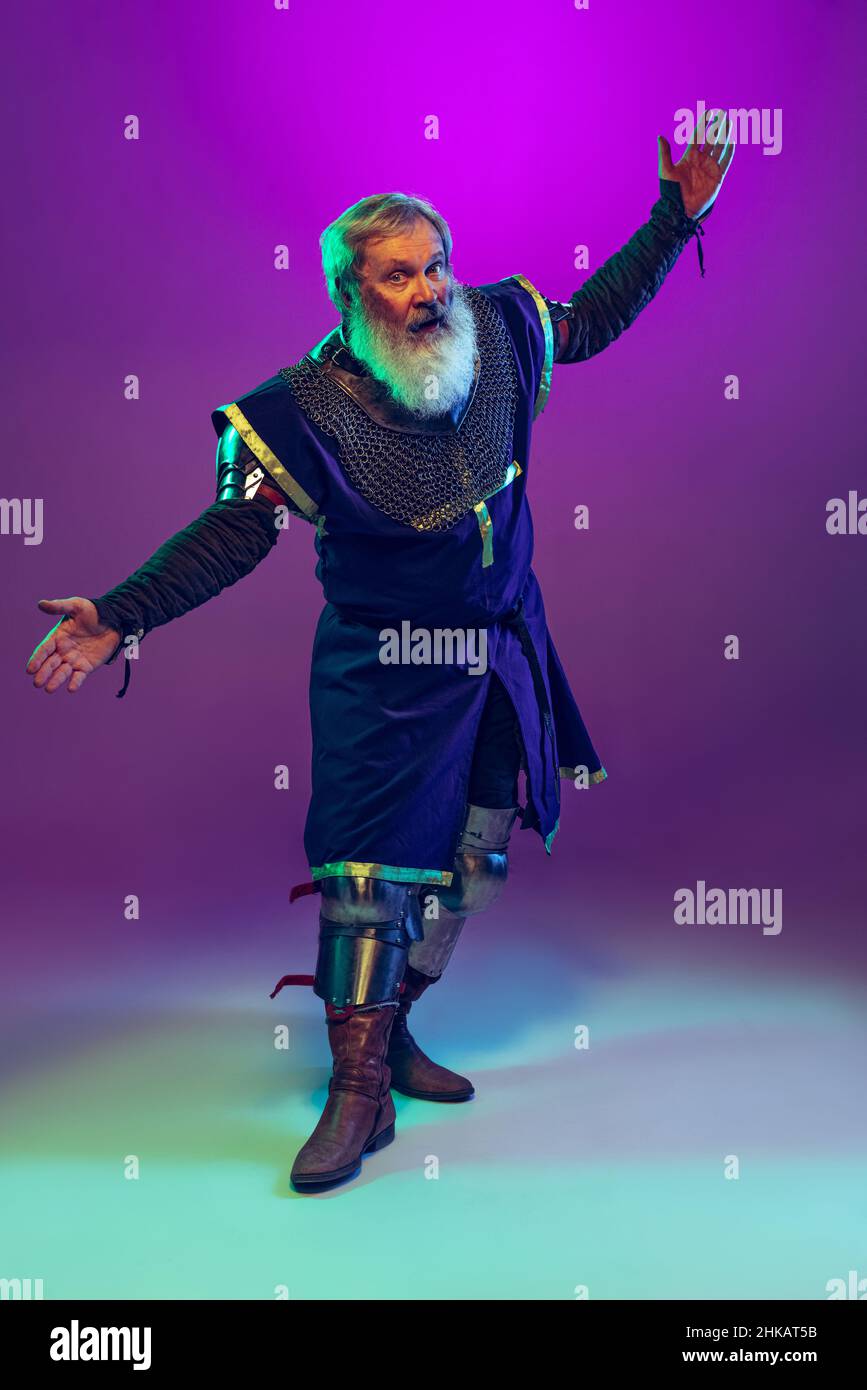 Comic portrait of senior grey-bearded man in image of medieval warrior ...