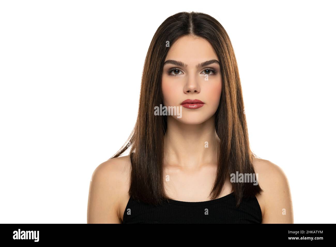 portrait of a serious teen girl with long straight hair on a white ...