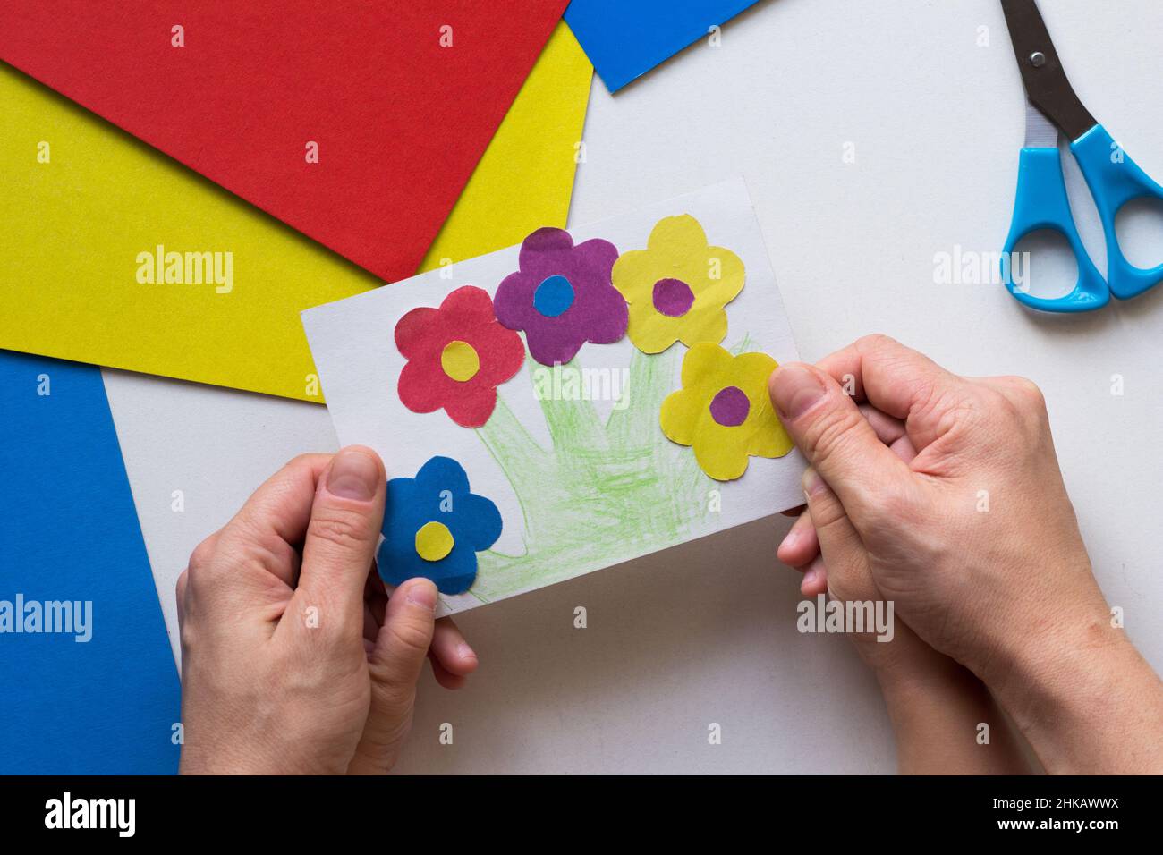 Handmade greeting card with flowers in child and woman hands on the ...
