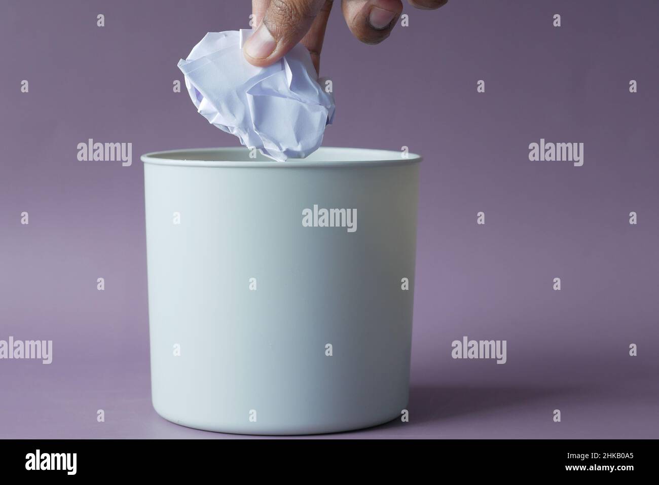 crumpled paper ball falling in a bin on purple background Stock Photo ...