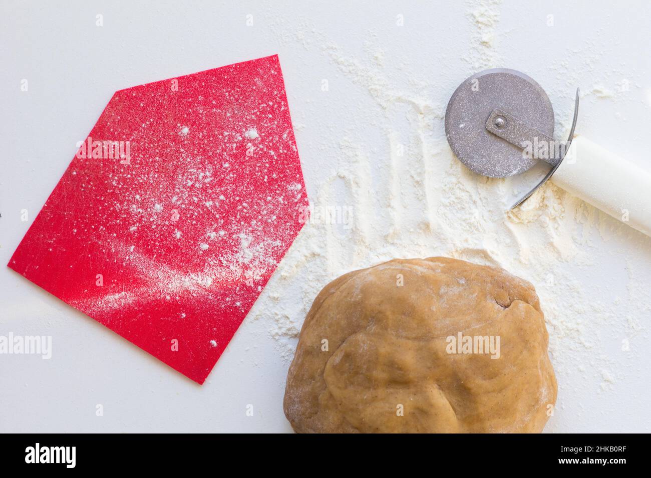 Homemade form for gingerbread house, ball of raw gingerbread dough and ...