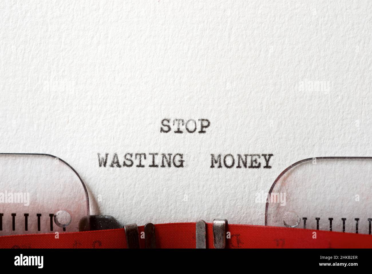 Stop wasting money text written with a typewriter Stock Photo - Alamy