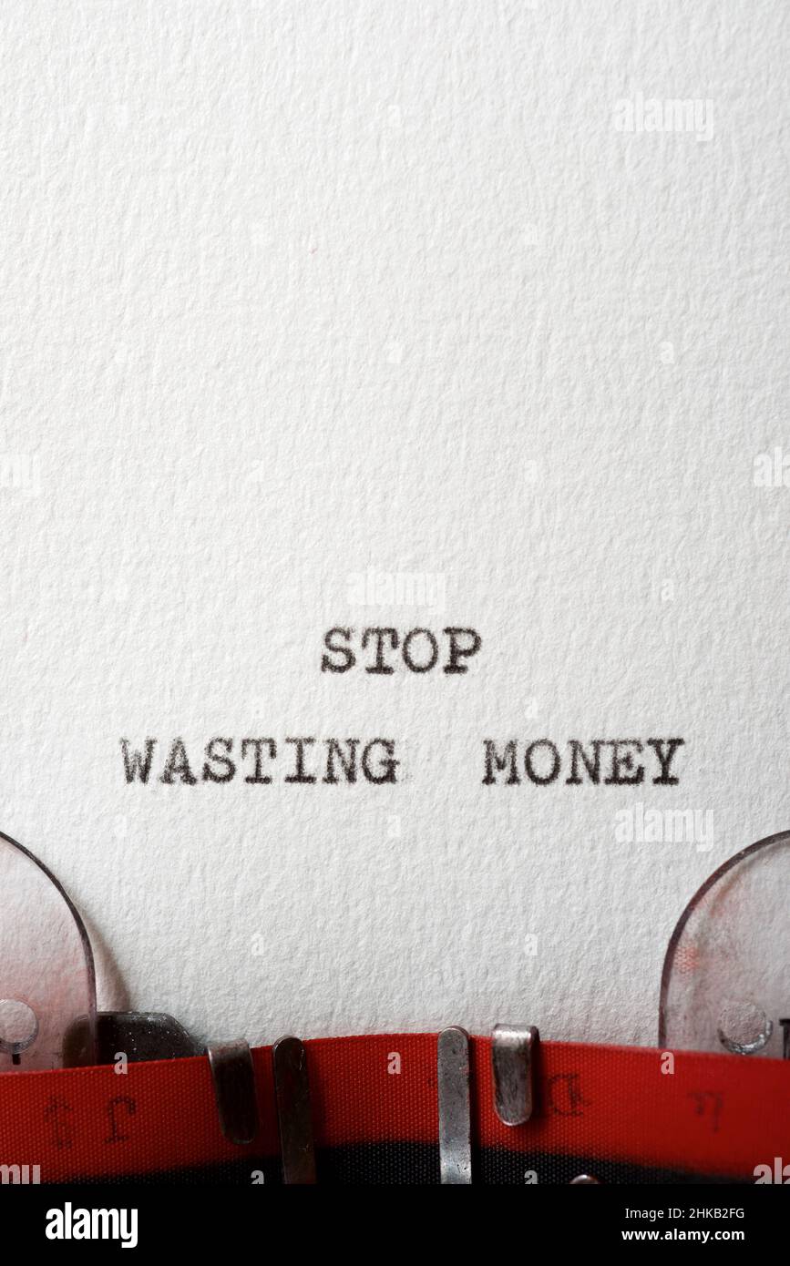 Stop wasting money text written with a typewriter Stock Photo - Alamy