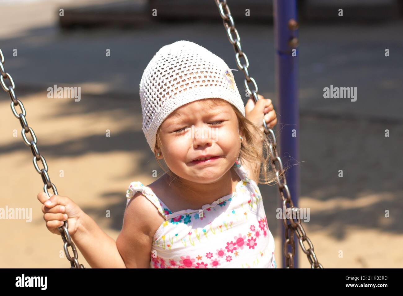 Crying child swinging in summer park Stock Photo - Alamy