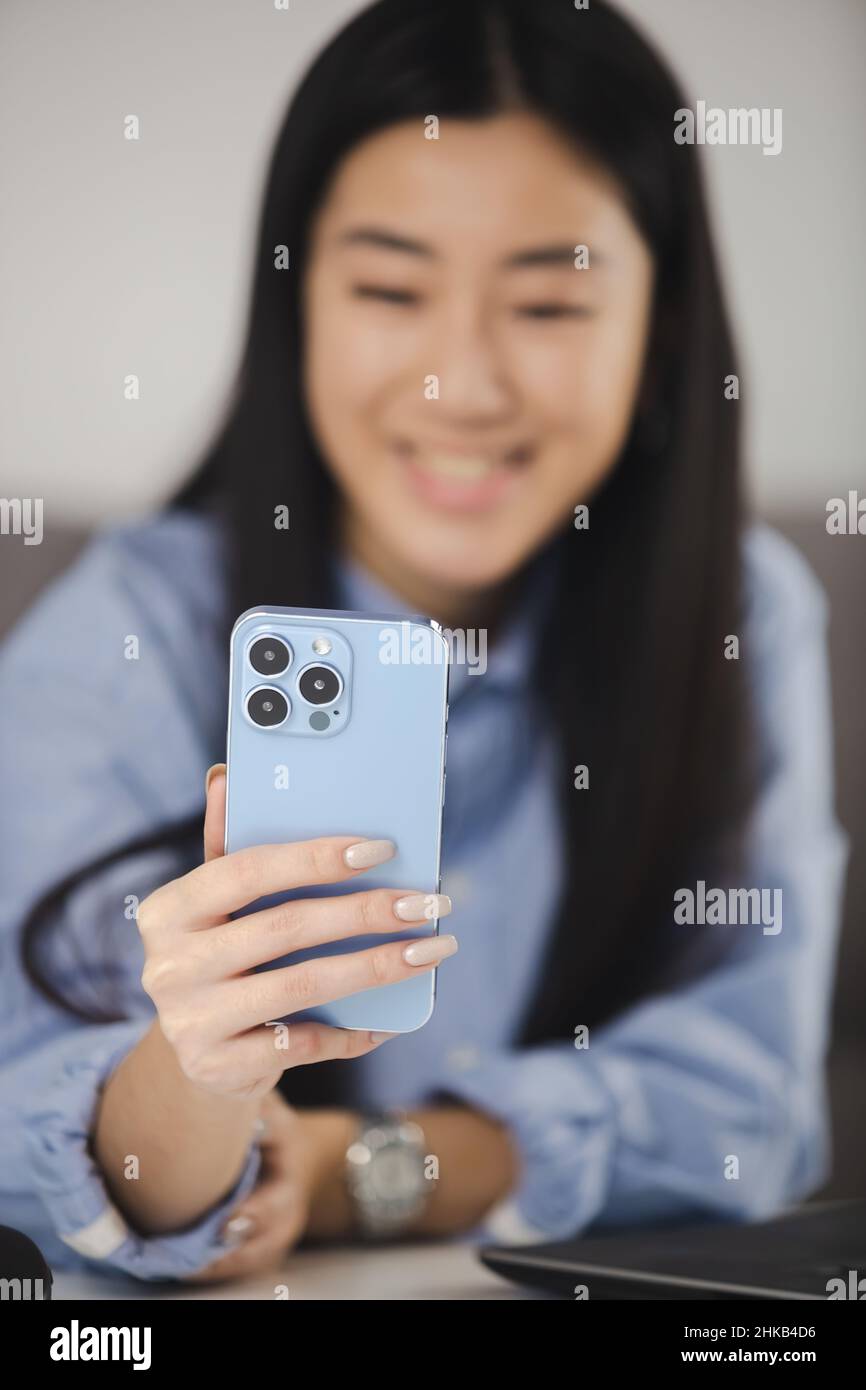 Young asian girl doing video call with modern smartphone. Happy ...
