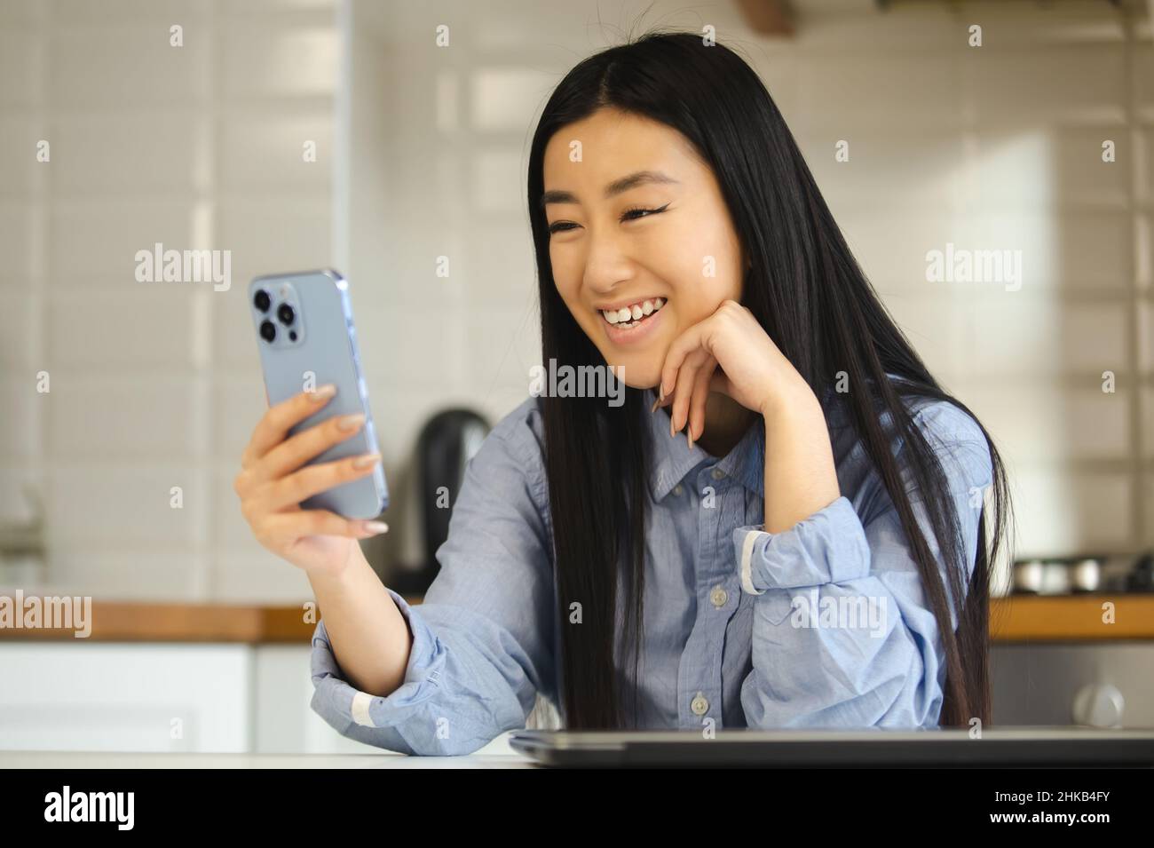 Happy asian girl doing video call on mobile phone. Cheerful Vietnamese ...