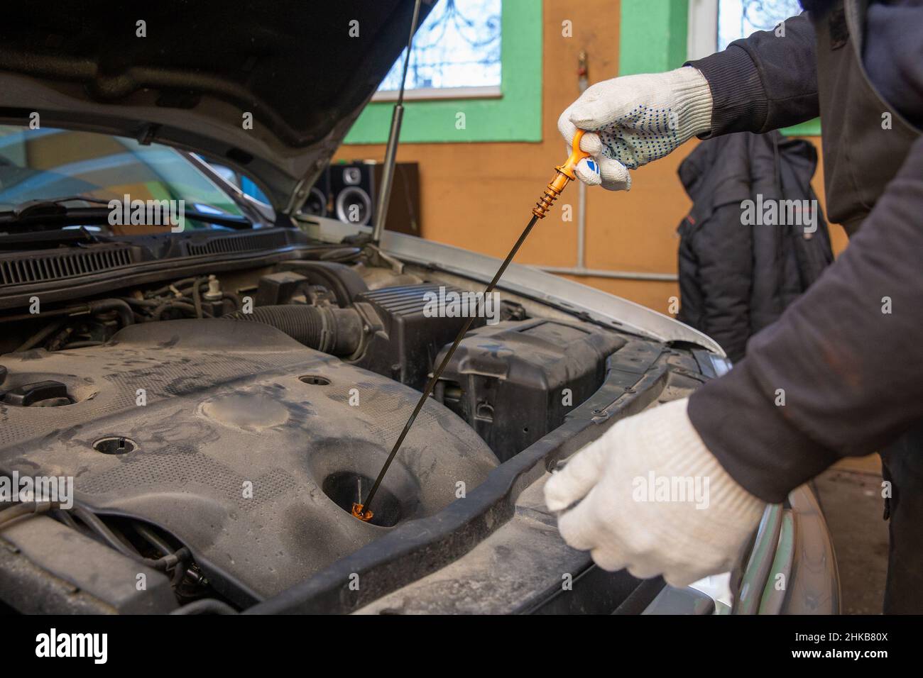 Car mechanic checking oil level in a mechanical workshop. Car repair ...