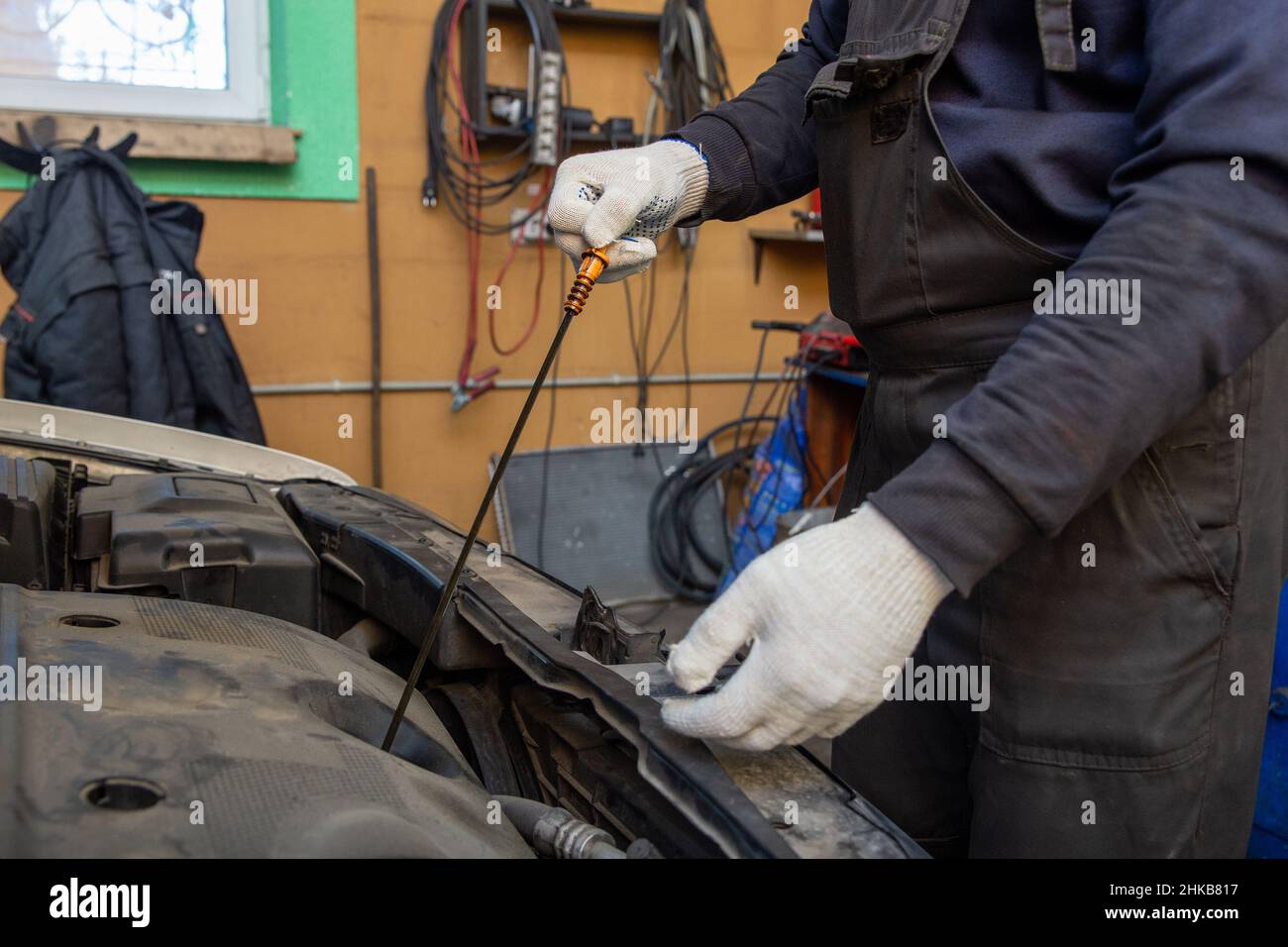 Car mechanic checking oil level in a mechanical workshop. Car repair ...