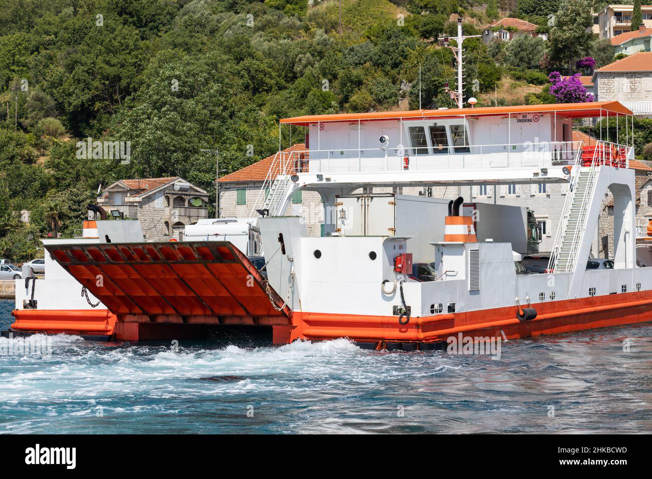 Ferry ship transporting cars and lorries through bay in mediterranean ...