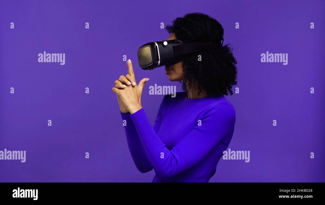 curly african american woman in vr headset showing finger gun gesture ...