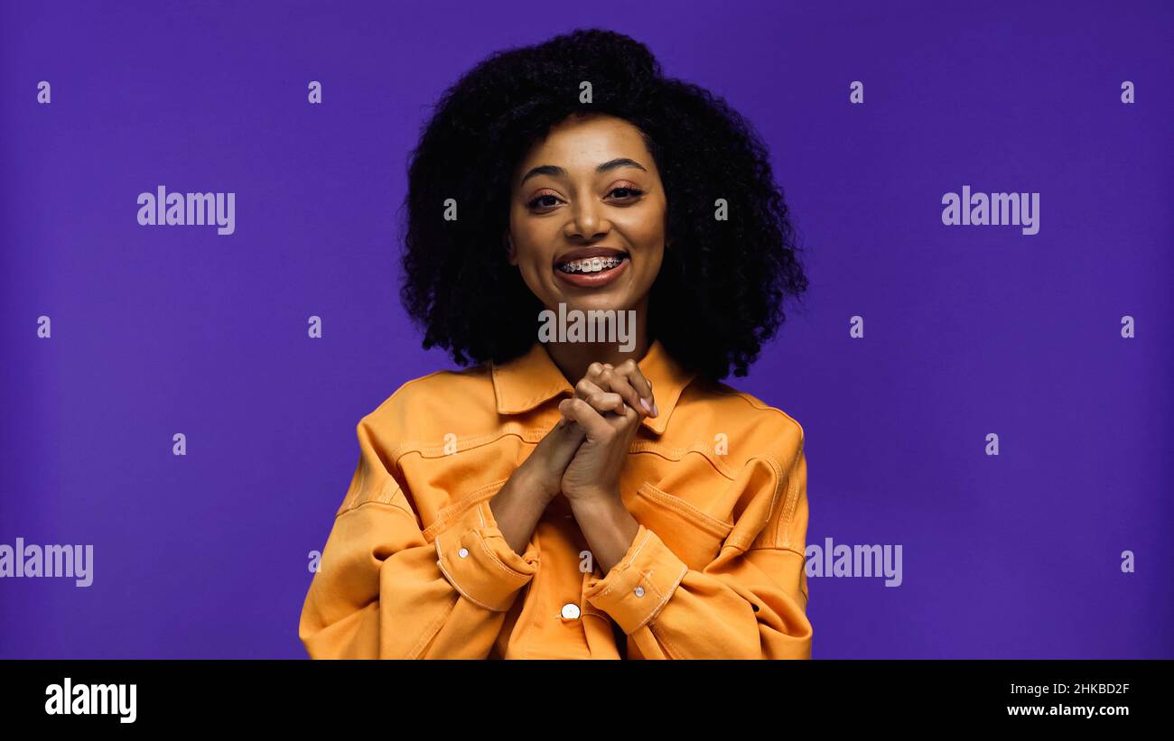 cheerful african american woman with braces standing with clenched ...