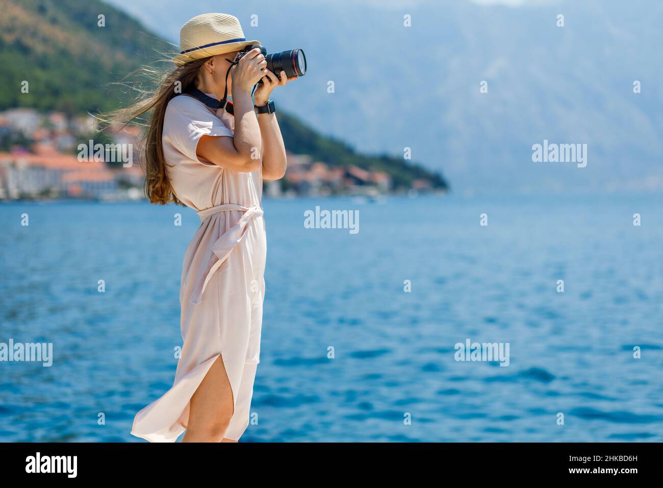 Young travel lady in dress takes photo with professional camera at ...