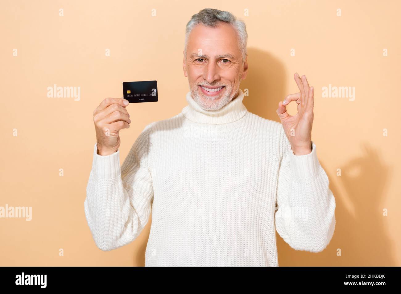 Portrait of attractive cheerful grey-haired man holding in hand bank ...