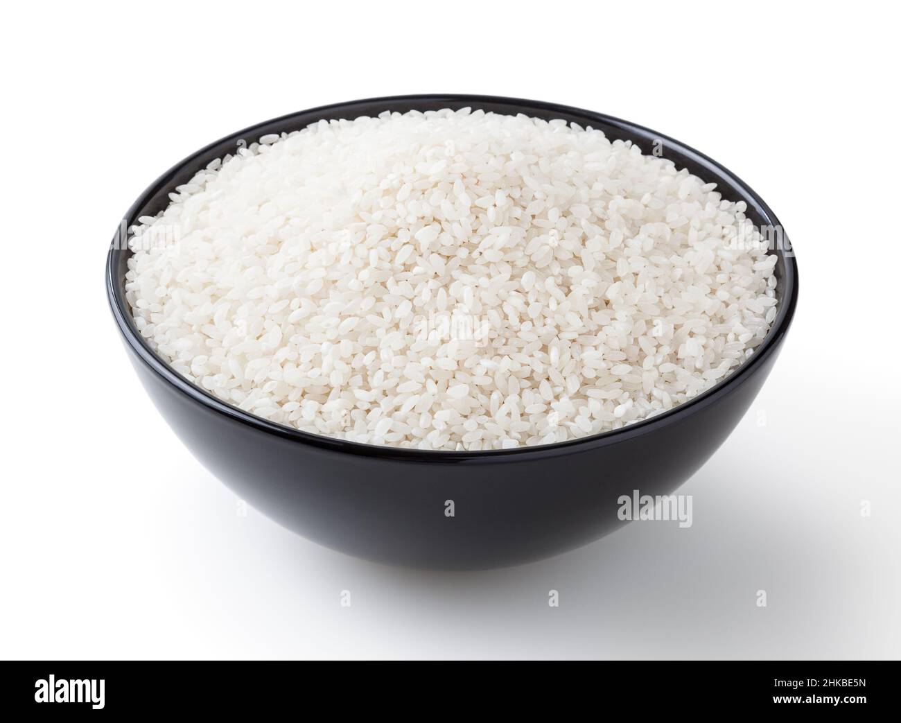 Uncooked round rice in black bowl isolated on white background with ...