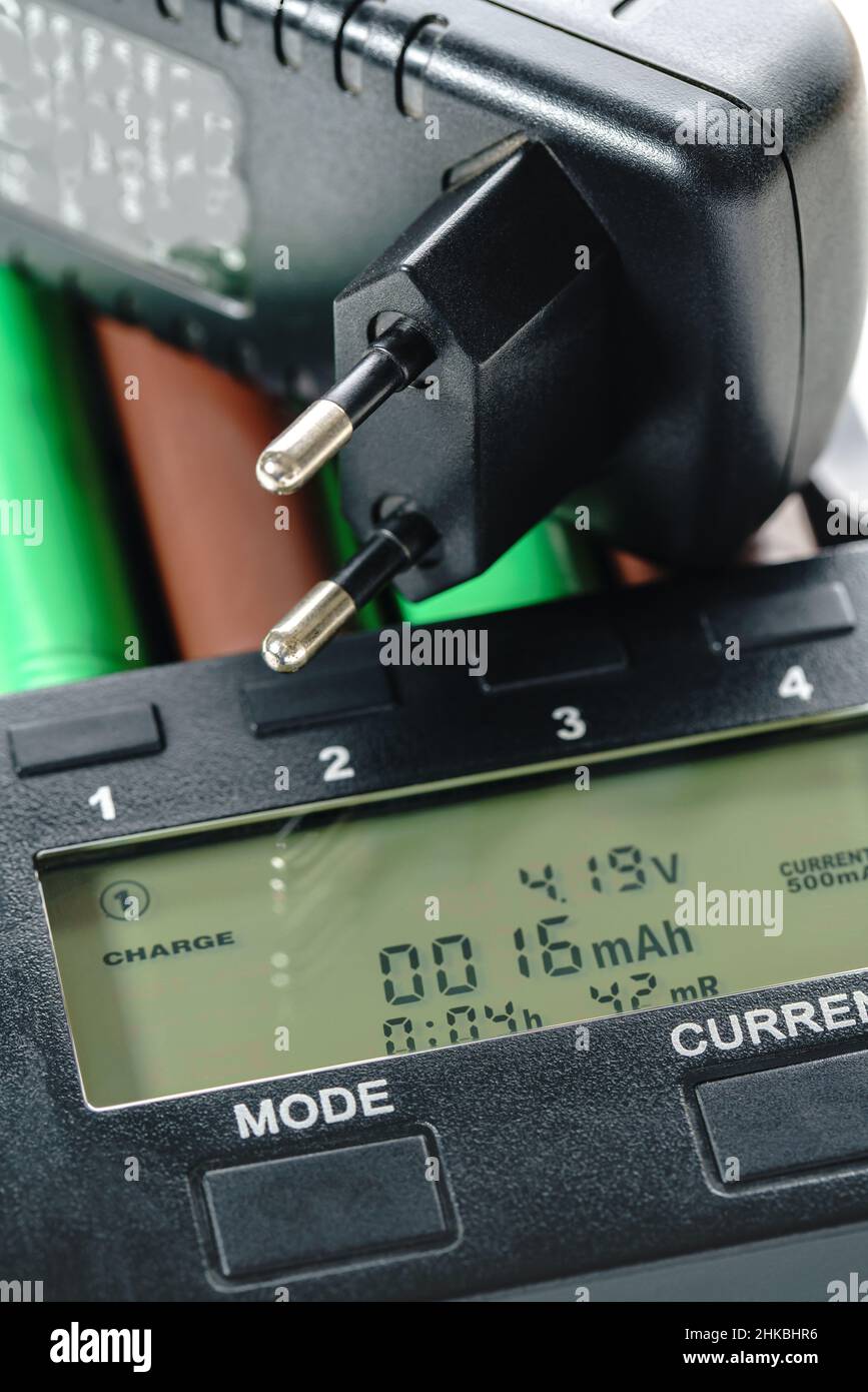 electronic charger with batteries close-up, background Stock Photo - Alamy