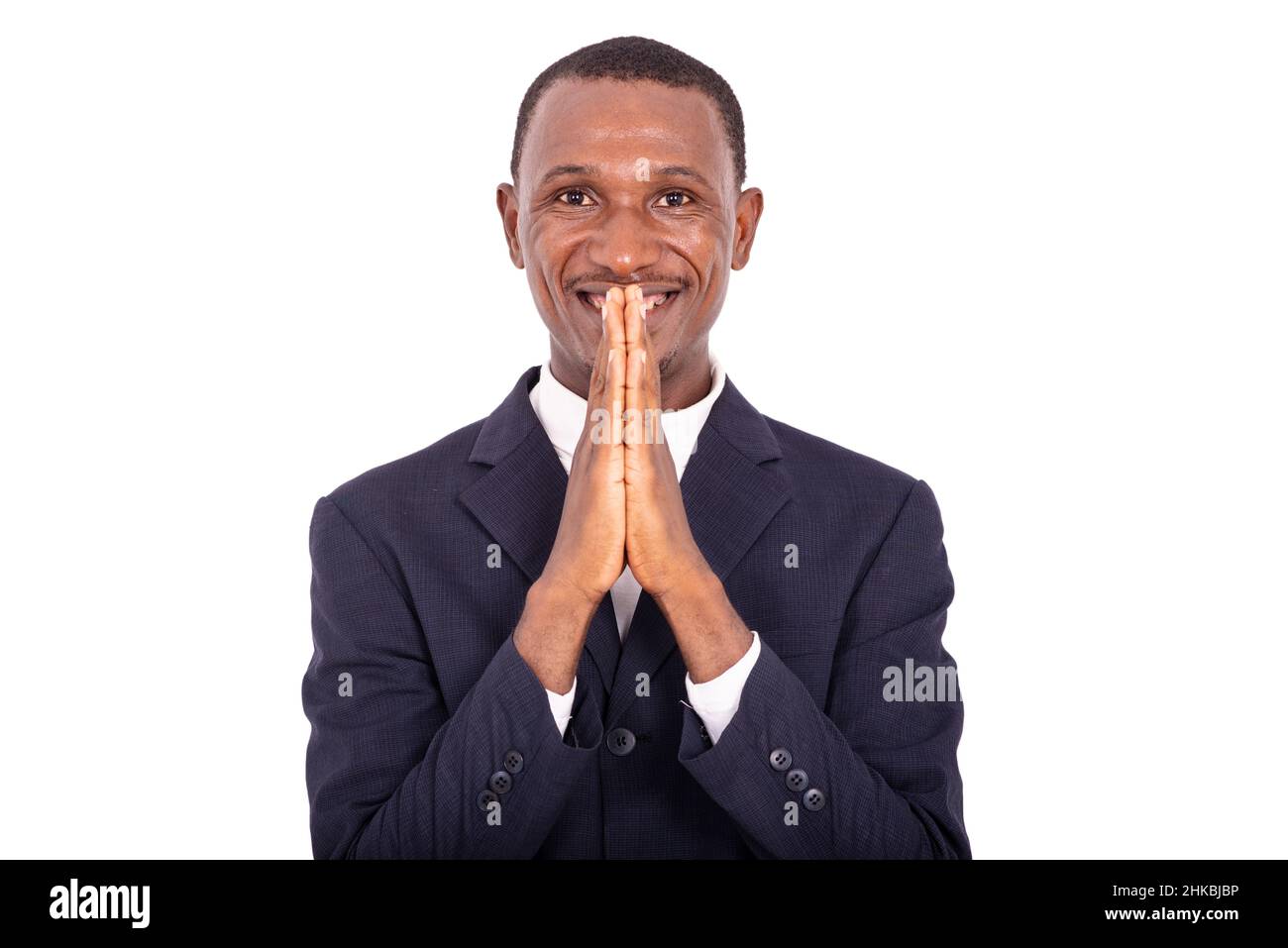 adult businessman holding hands folded against lips and smiling at ...