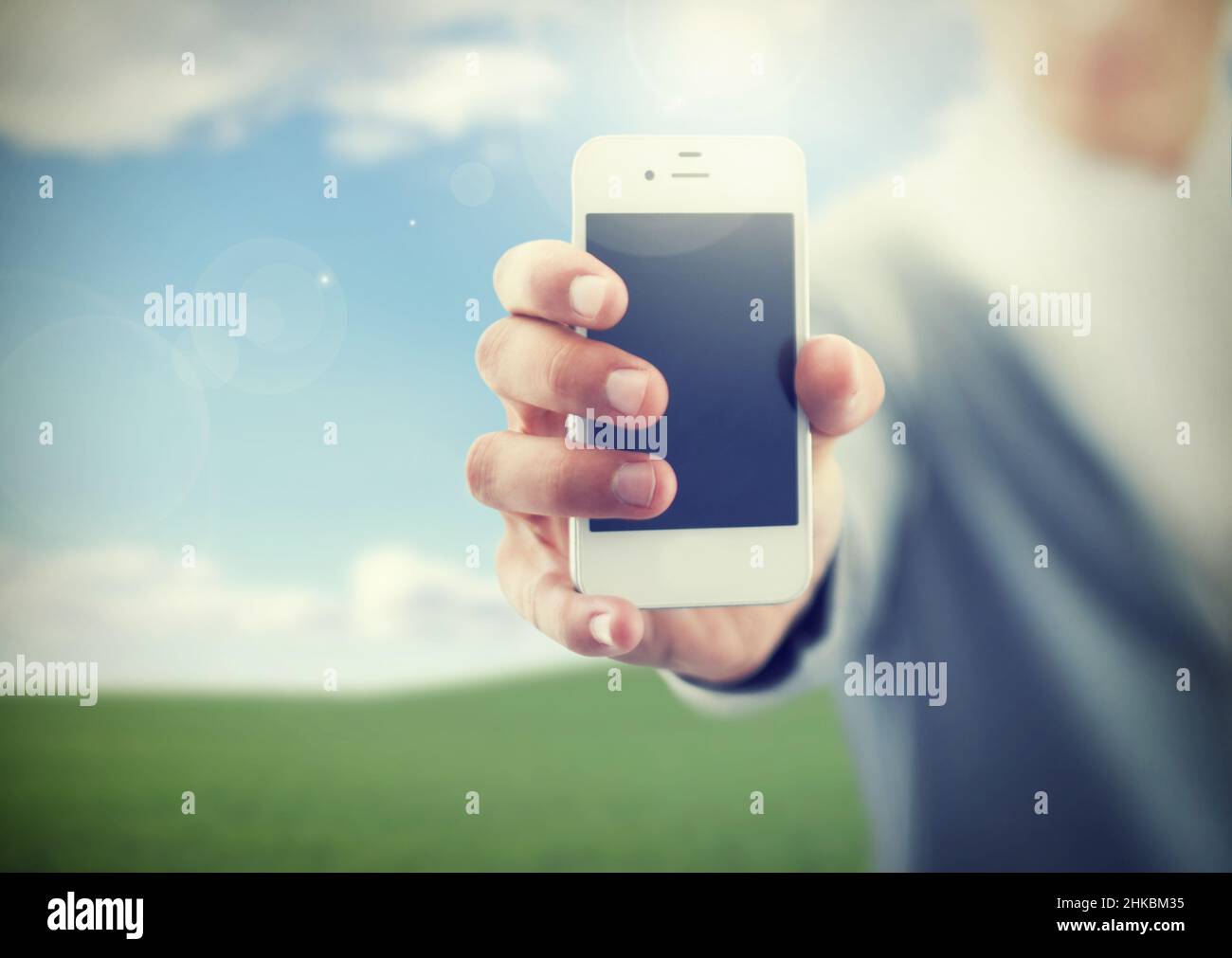 Presenting the newest smartphone. A young man holding his smartphone ...
