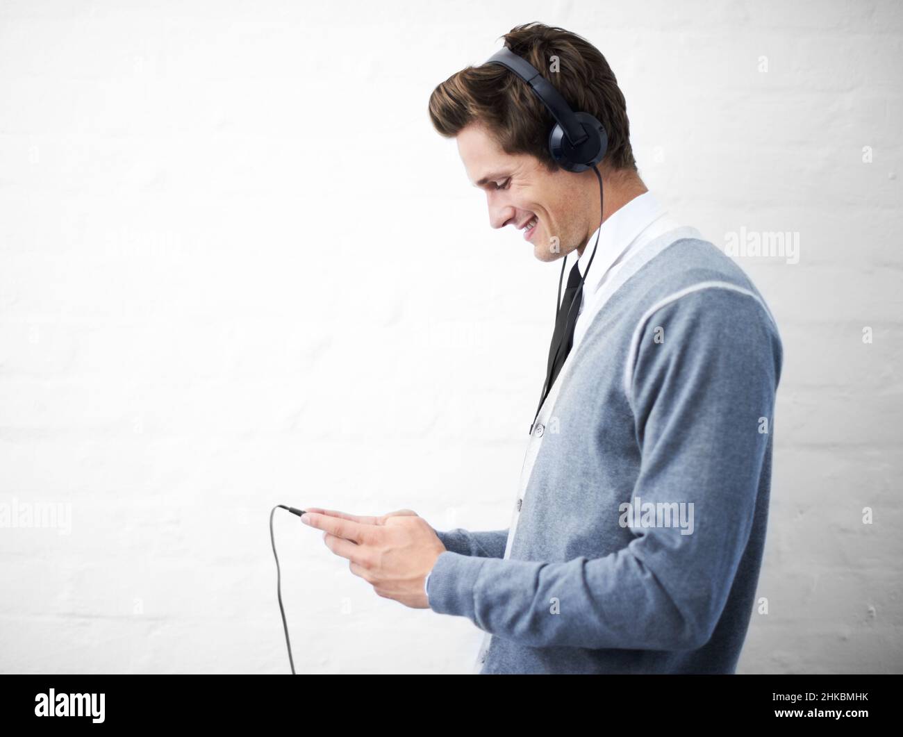 Queuing his favorite song. A young nerdy guy holding an mp3 player ...