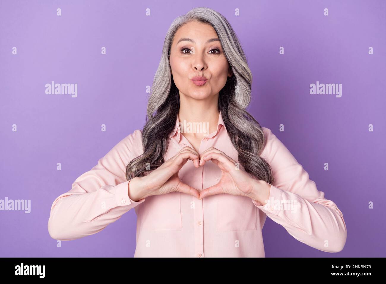 Portrait of attractive trendy affectionate woman showing heart sign ...