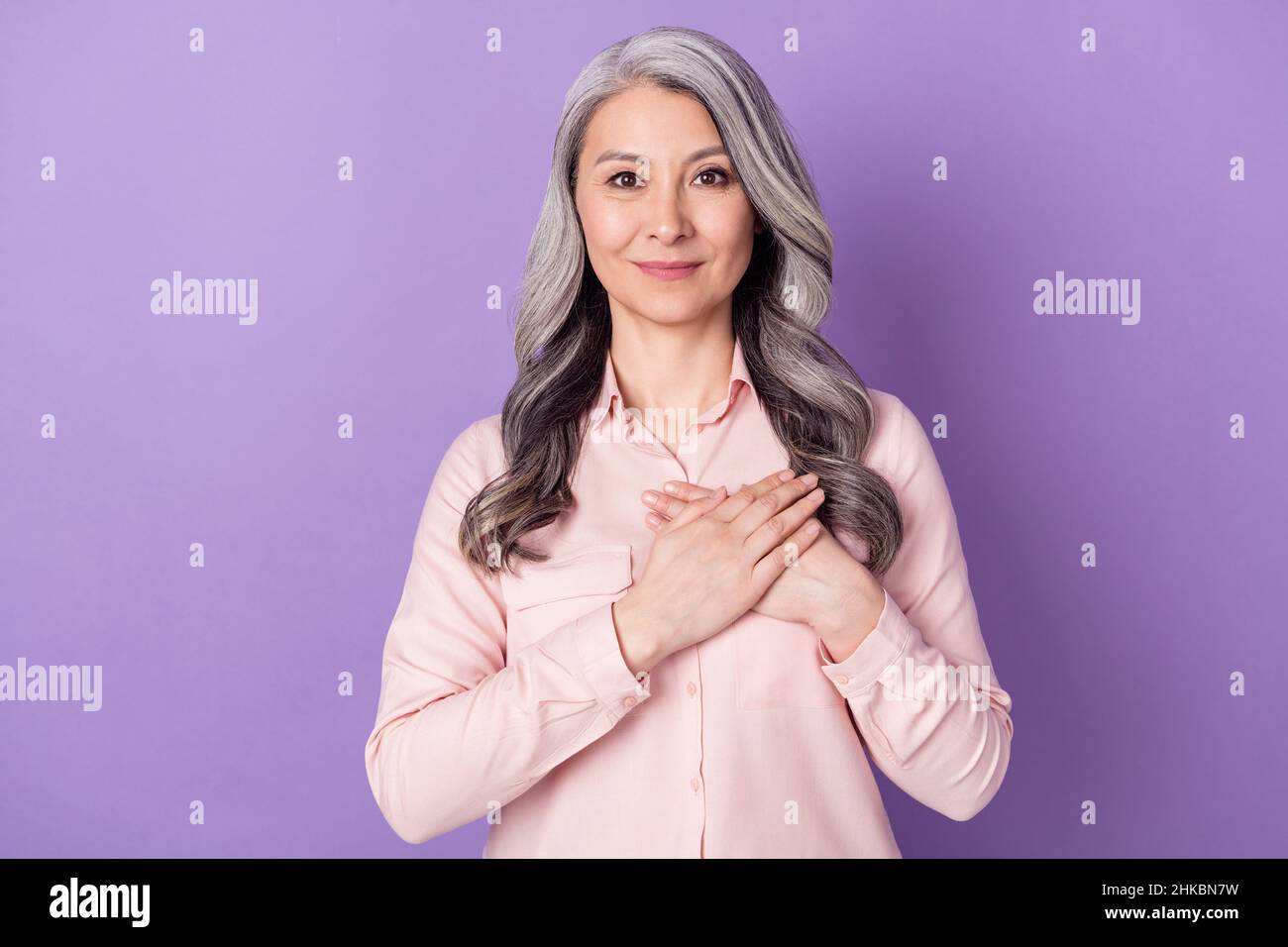 Portrait of attractive cheery honest affectionate woman touching heart ...